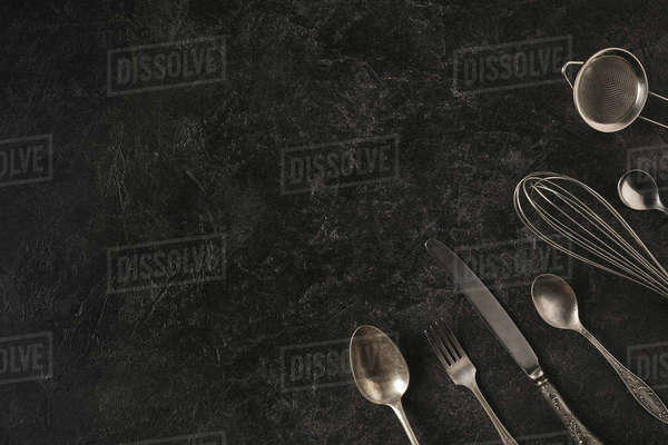 Top view of arranged vintage silverware, whisk and sieve for baking ...