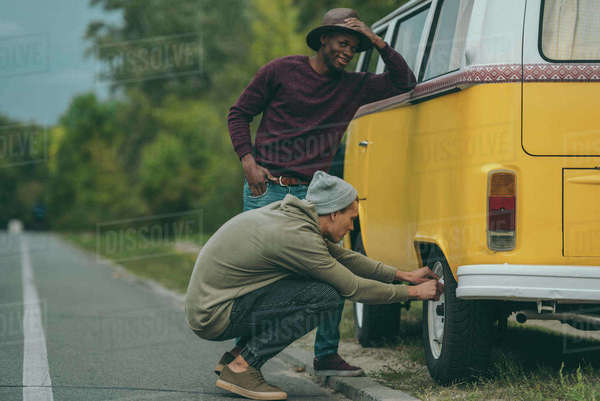 Sad multiethnic friends near broken minivan on road - Stock Photo ...