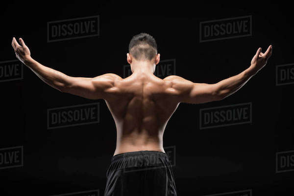 Back view of shirtless muscular man standing with open arms isolated on ...