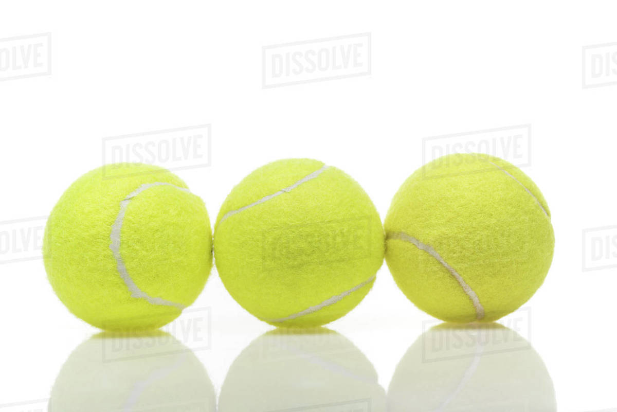 Closeup shot of three tennis balls in a row, isolated on white ...