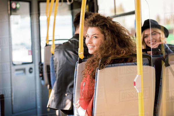 Beautiful smiling young women sitting together in city bus - Royalty ...