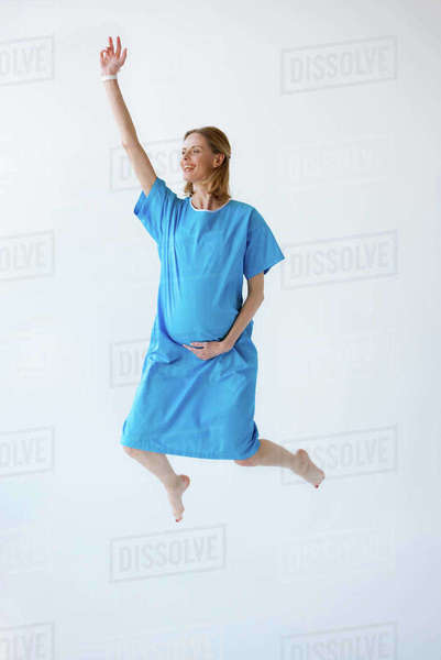Cheerful Caucasian pregnant woman touching her belly and jumping ...