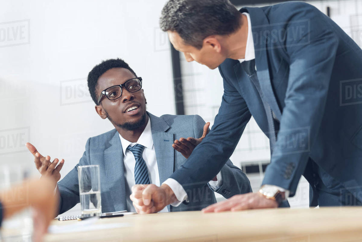 Multiethnic businessmen having conversation at office - Royalty-free ...