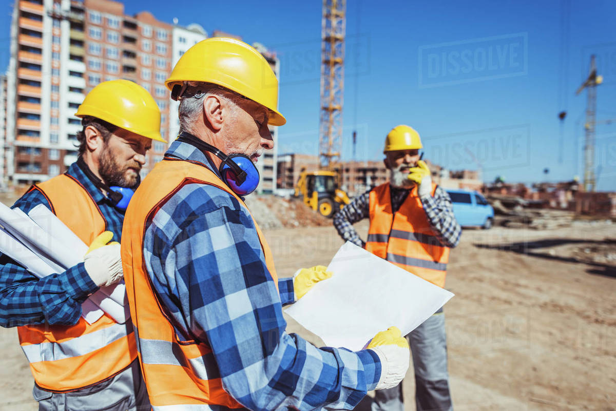 Foreman Examining A Building Plan While Standing At Construction Site