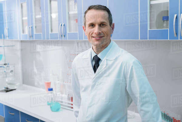 Professional scientist in lab coat, standing in laboratory, looking at ...