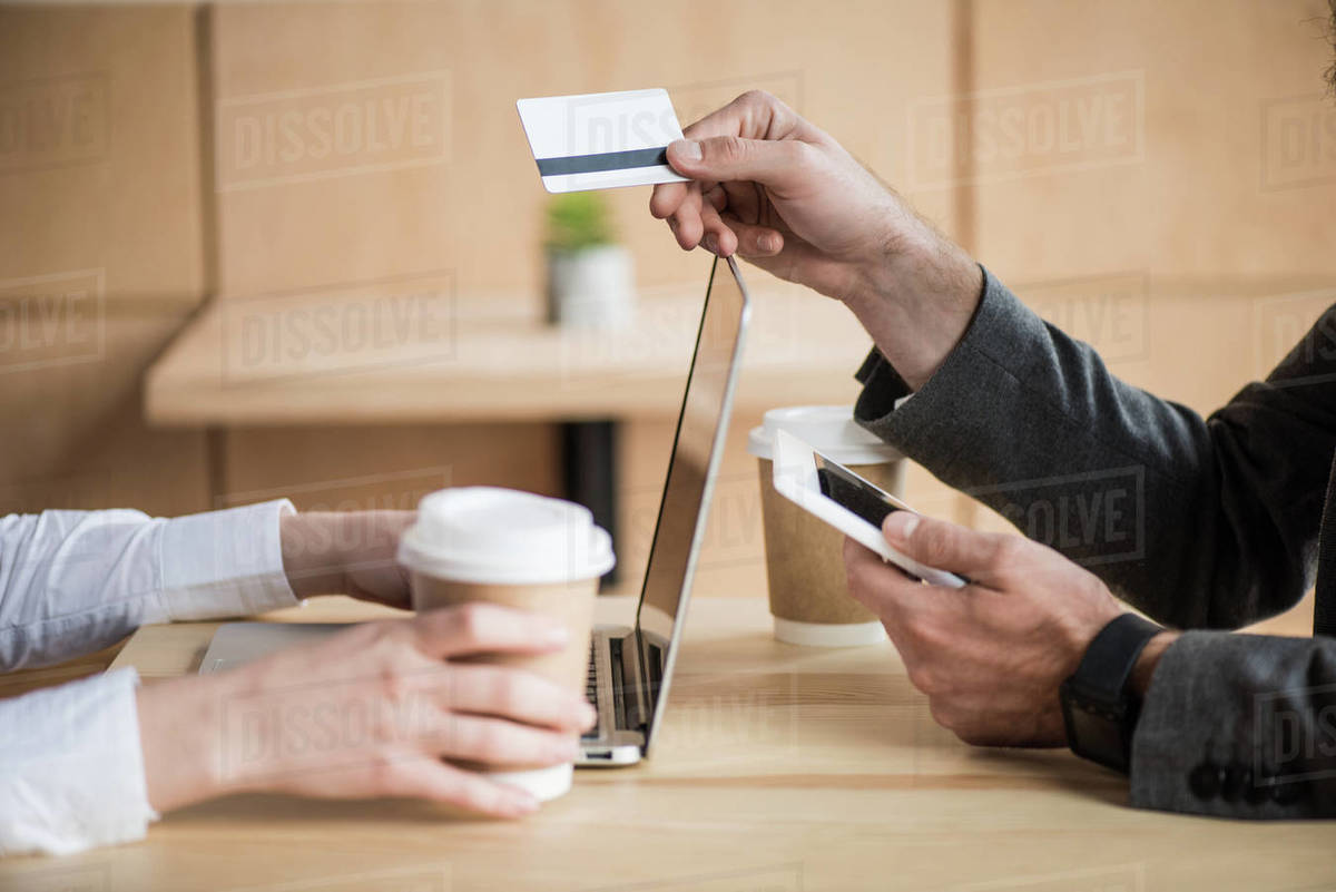 Cropped shot of businessman giving credit card to female partner over ...