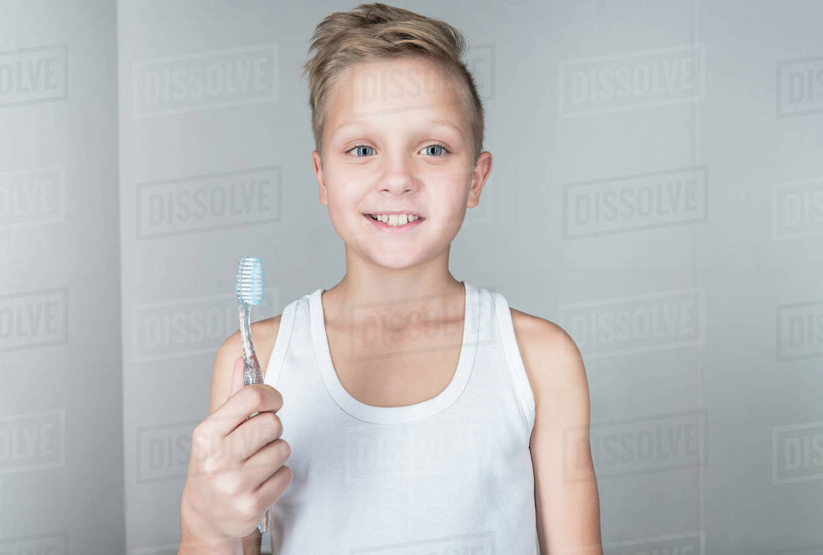Adorable little boy holding toothbrush and smiling at camera - Stock ...
