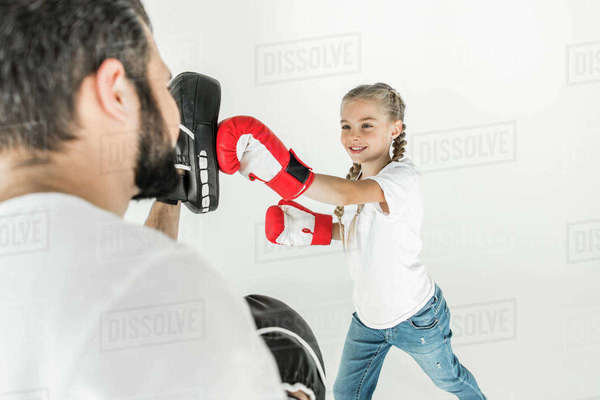Cropped shot of father and smiling daughter boxing together isolated on ...