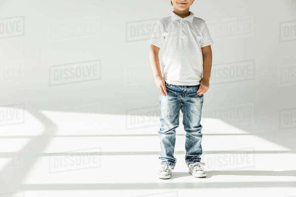Cropped shot of cute smiling little boy standing on white - Royalty ...