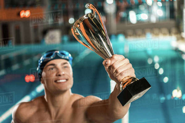 Swimmer with trophy cup at competition swimming pool - Stock Photo ...