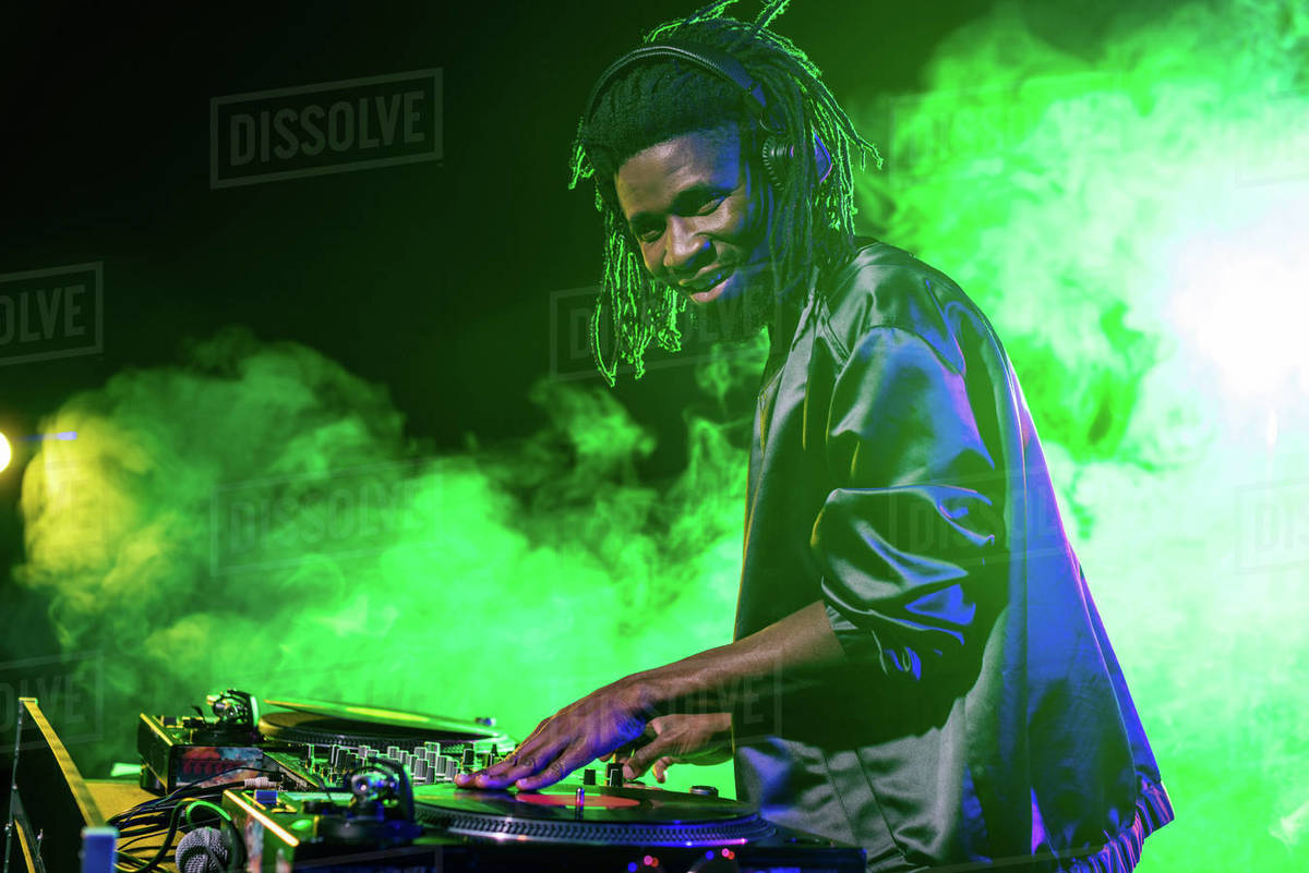 Professional African American dj in headphones with sound mixer in ...