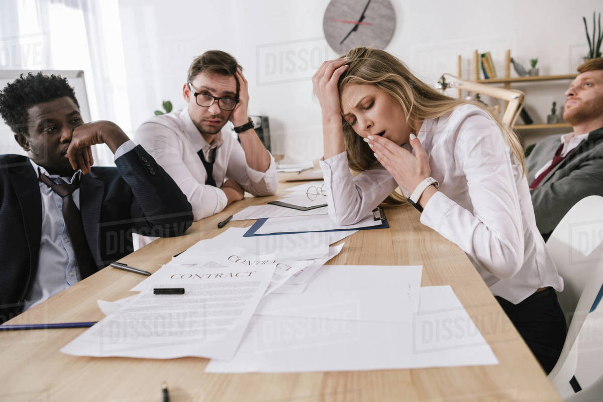 group of overworked business people sitting t conference hall at office ...