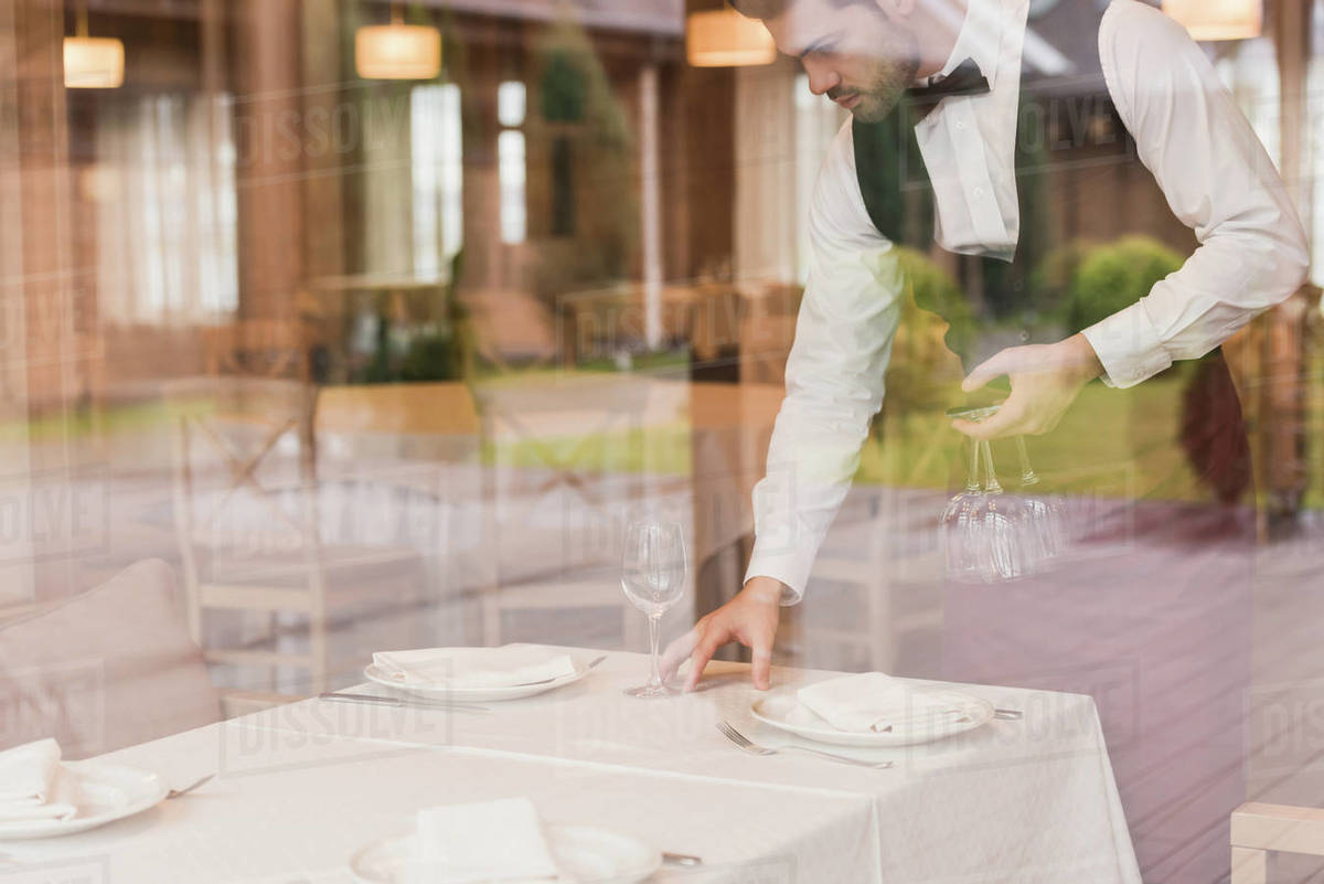 View through the window on a waiter serving table - Stock Photo - Dissolve