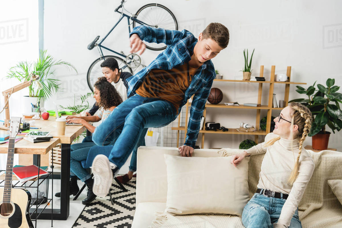 Caucasian teen boy jumping over sofa at home - Royalty-free Stock Photo ...