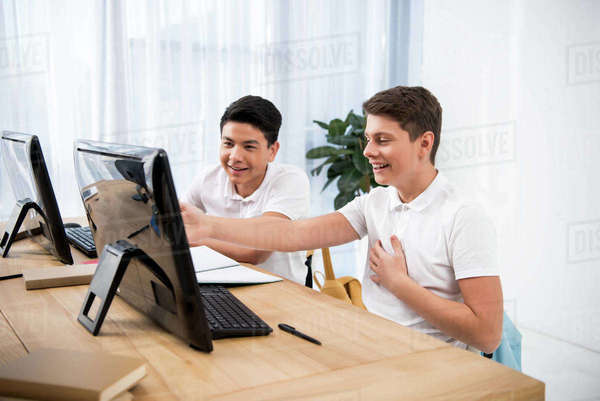 Student pointing on screen to his classmate and laughing - Stock Photo ...