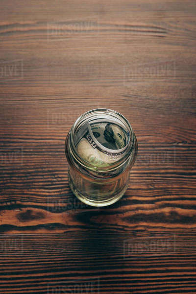Glass jar with dollar banknotes on wooden tabletop - Royalty-free Stock ...