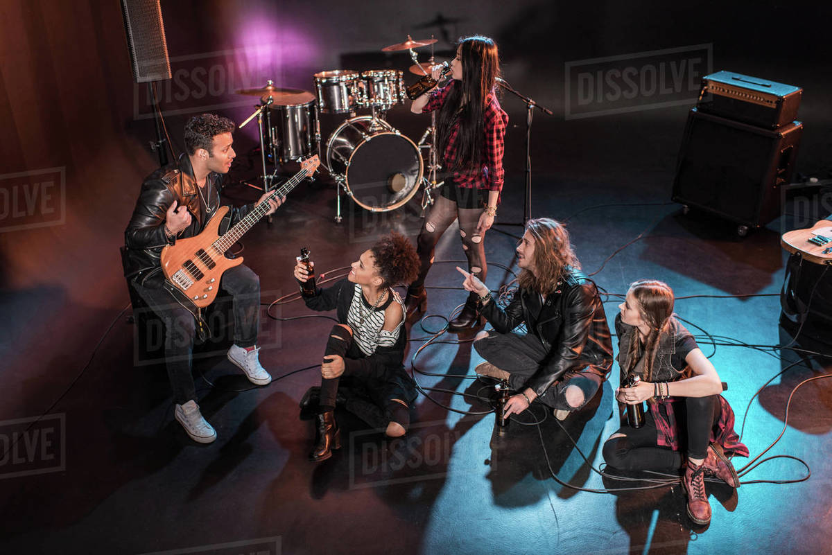 Young rock and roll band drinking beer after concert on stage - Stock ...