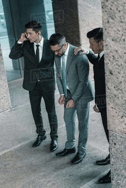 Security guards standing with male suspect - Stock Photo - Dissolve