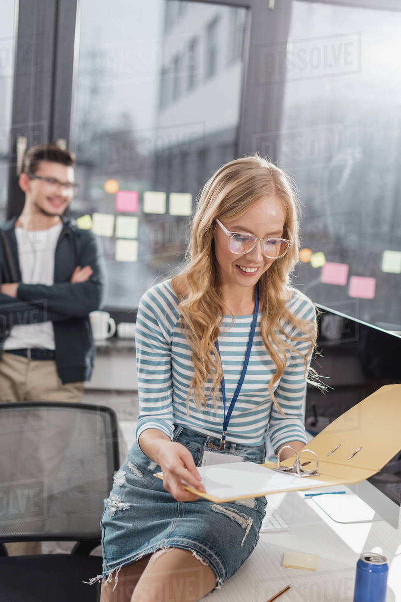 Young woman looking at folder with documents at modern office - Stock ...