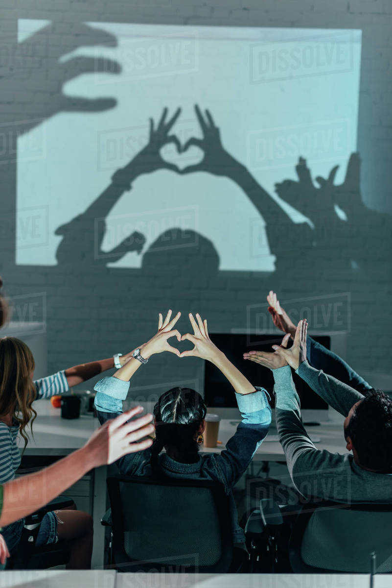 Young people playing with shadows after work in modern office - Royalty ...
