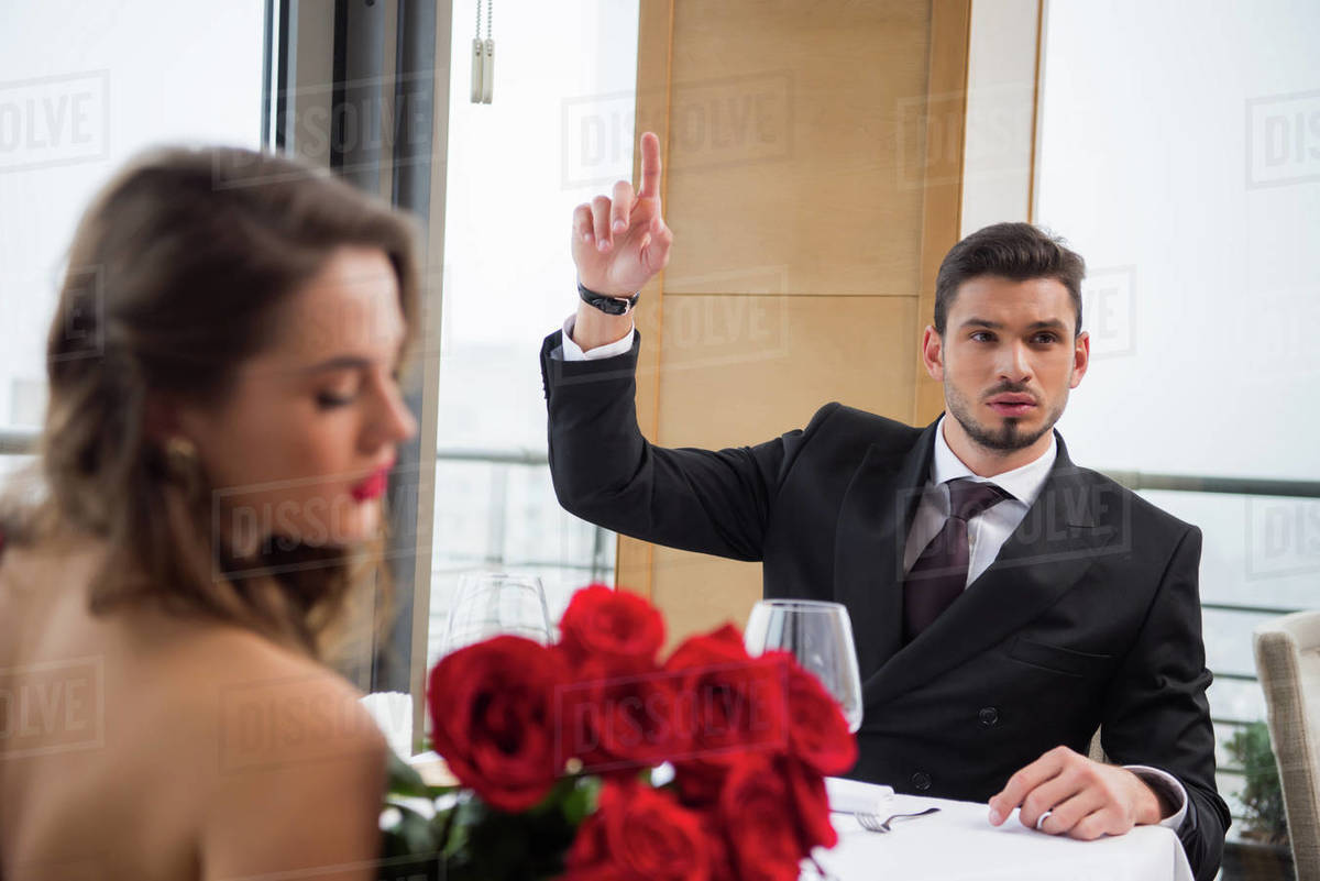 Selective focus of man calling for waiter in restaurant - Stock Photo ...