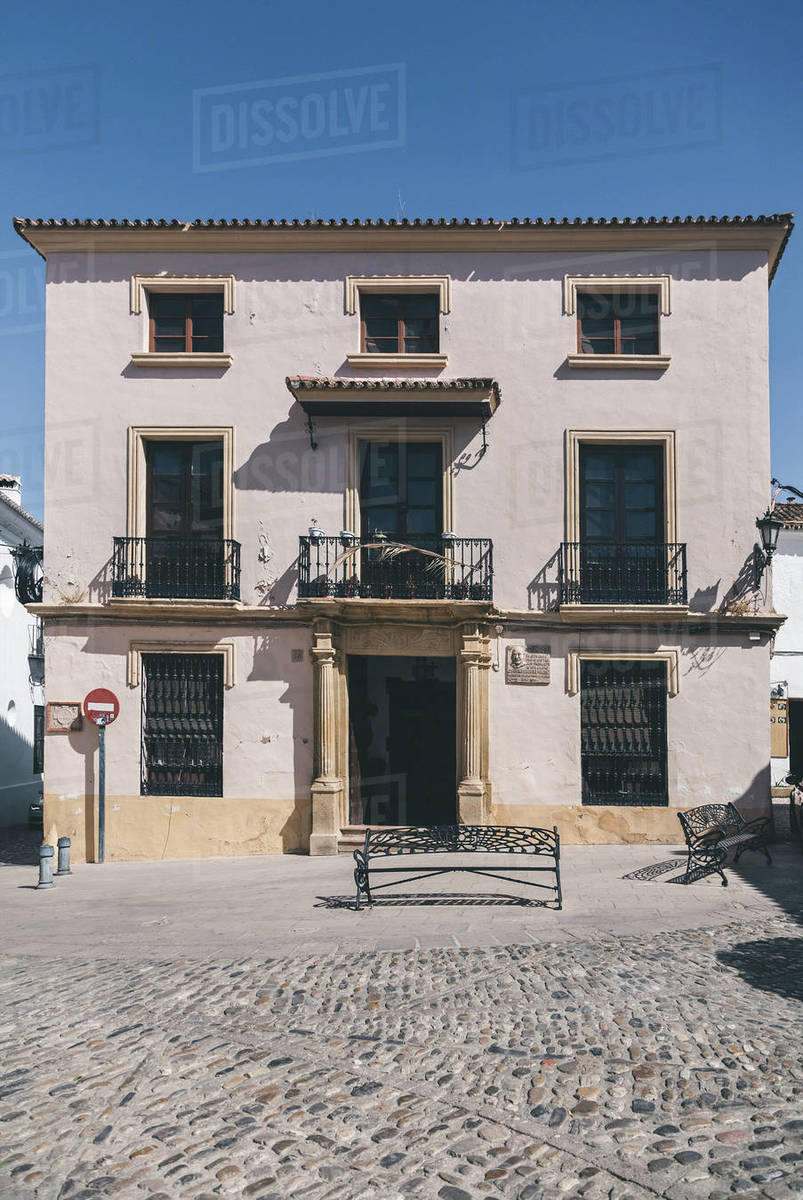 Facade of small Spanish building under blue sky - Stock Photo - Dissolve