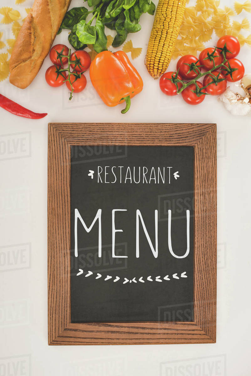 Top view of restaurant menu in wooden frame and fresh ingredients on ...
