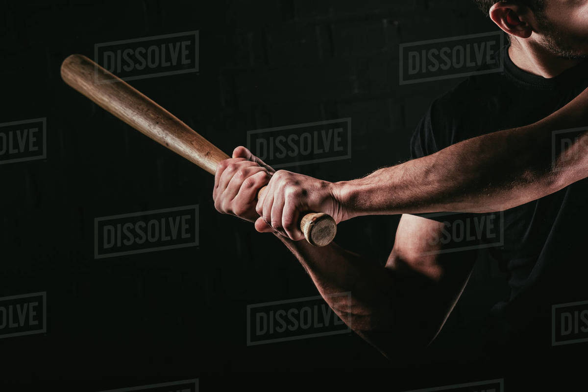 Cropped shot of young man playing baseball with bat isolated on black ...