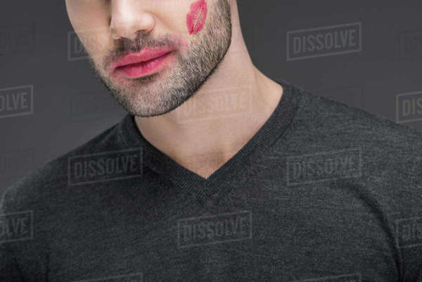 Man with kiss print on cheek, isolated on grey - Stock Photo - Dissolve