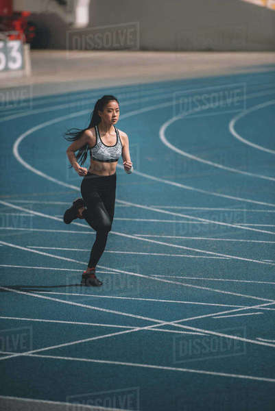 Asian sportswoman training on running track stadium, young girl running ...