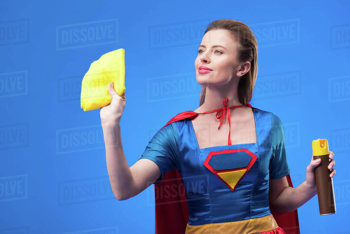 Portrait of beautiful superwoman with rag and detergent for cleaning ...