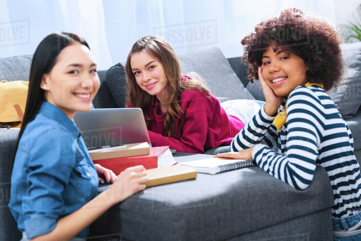 Portrait of smiling multicultural students looking at camera while ...
