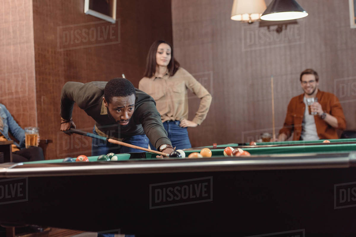 african american man playing in pool at bar with friends - Royalty-free ...