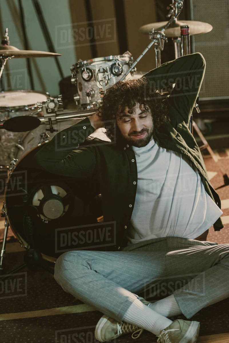 happy bearded drummer relaxign while leaning back on drum set - Royalty ...