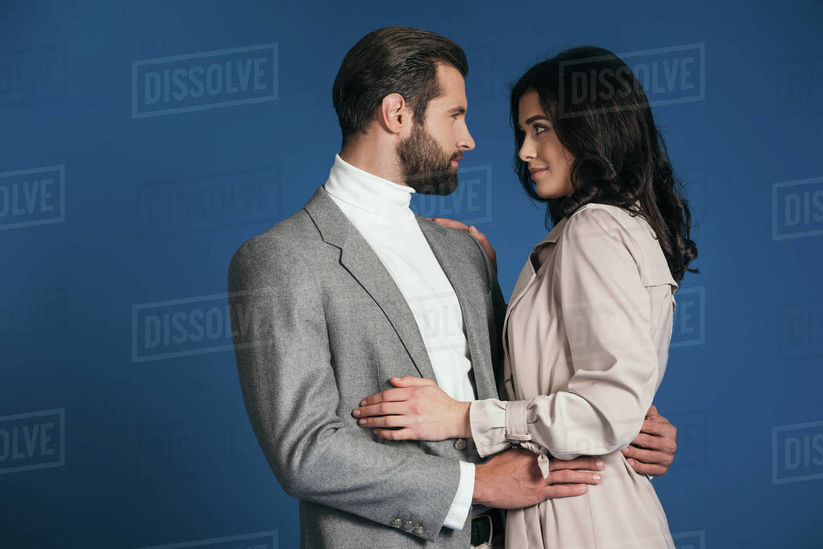 attractive boyfriend and girlfriend hugging isolated on blue - Royalty ...