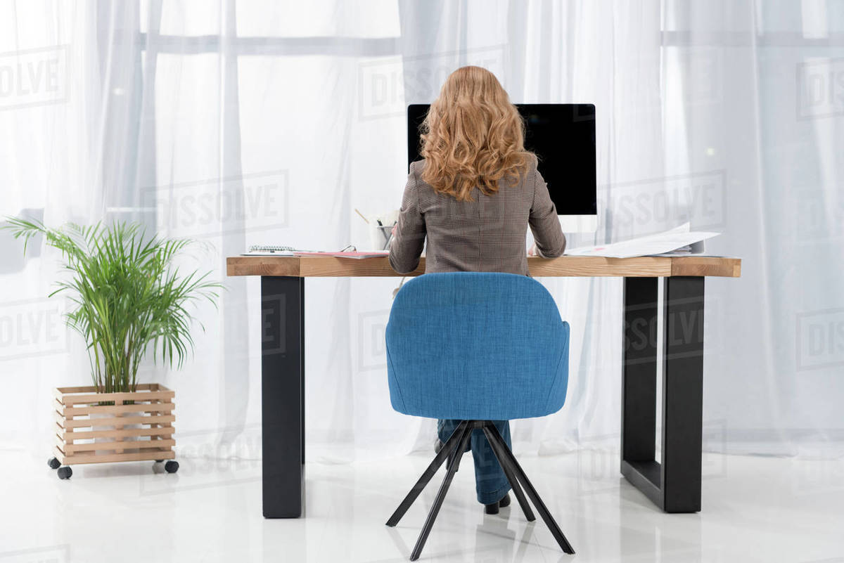 back view of businesswoman working at workplace with computer screen in ...