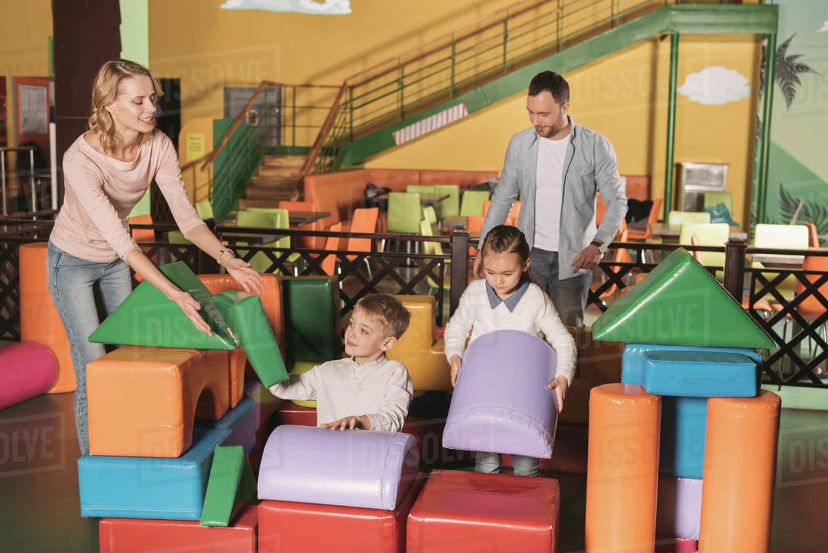 happy family with two kids playing with colorful blocks in game center ...