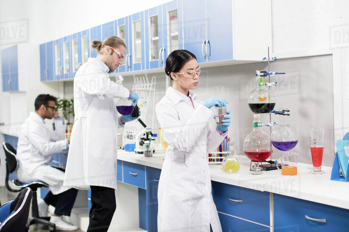 Group of young professional scientists making experiment in research ...