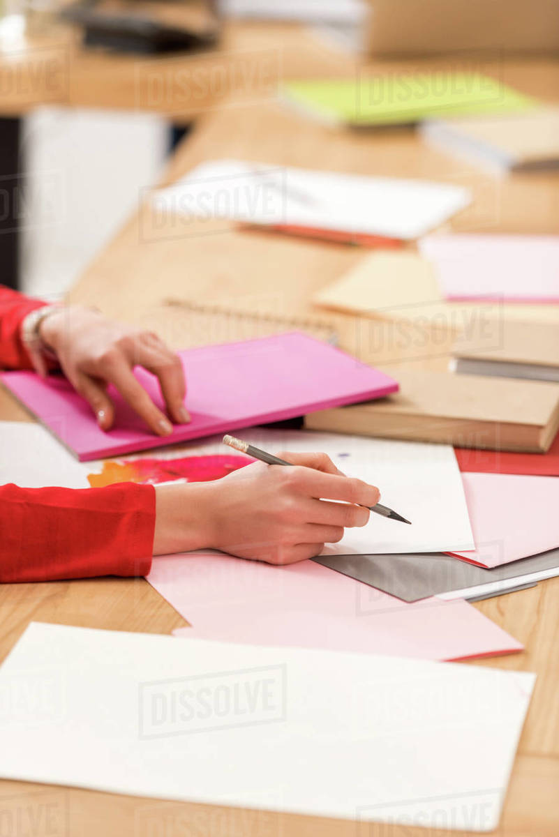 Cropped view of magazine editor working with documents in modern office ...
