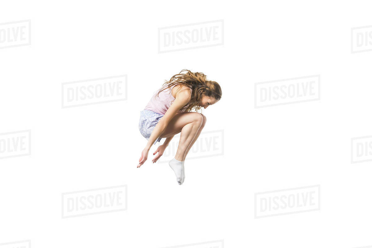 Side view of beautiful young woman jumping isolated on white - Royalty ...