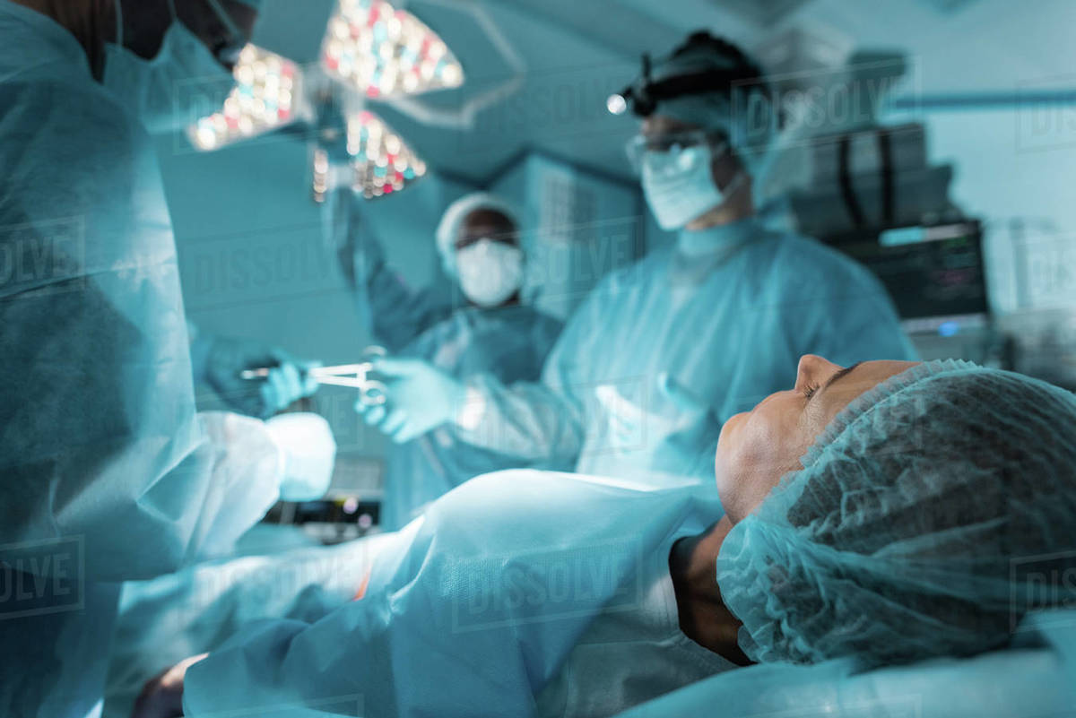 Patient lying on operating table during surgery - Stock Photo - Dissolve