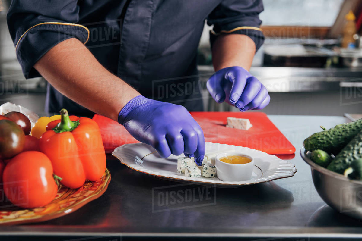 Cropped shot of chef putting cheese pieces on plate - Royalty-free ...