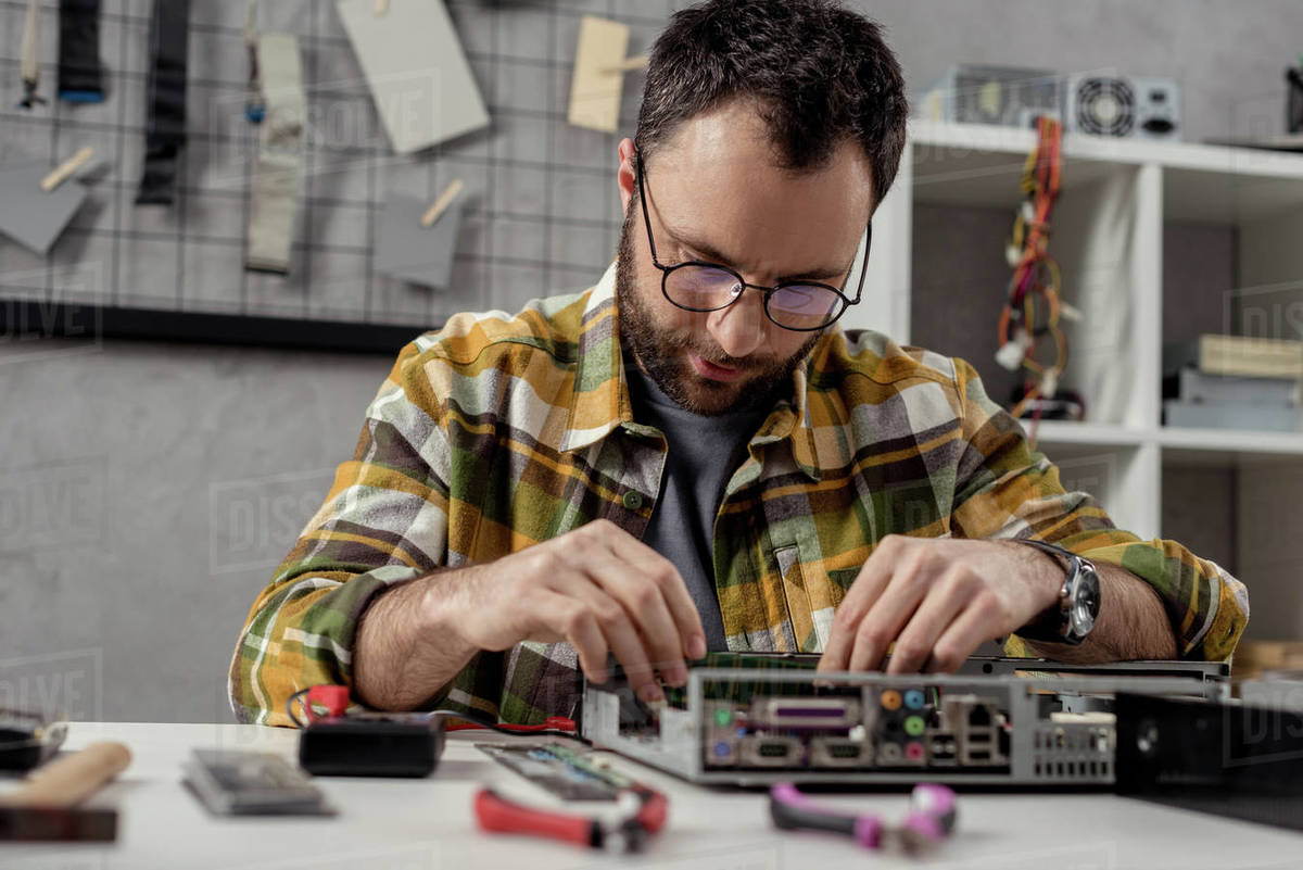 man looking down while fixing broken computer - Royalty-free Stock ...