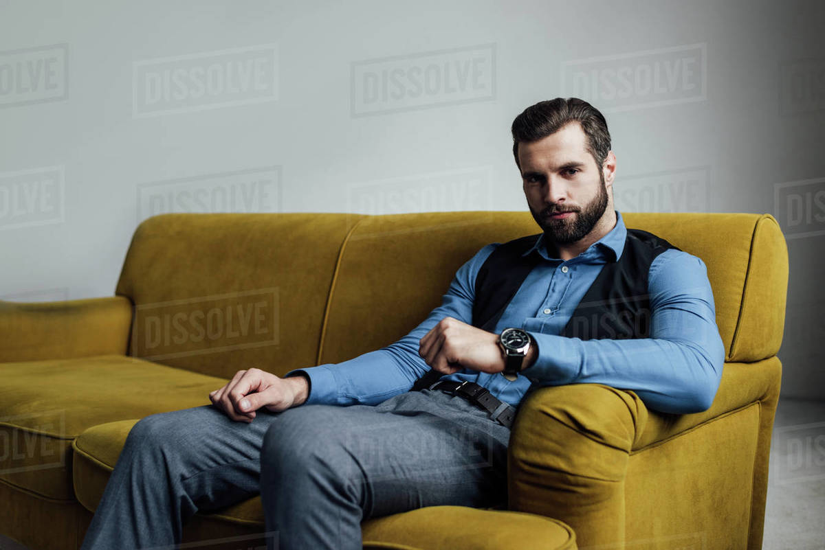 Stylish elegant man sitting on yellow sofa - Royalty-free Stock Photo ...