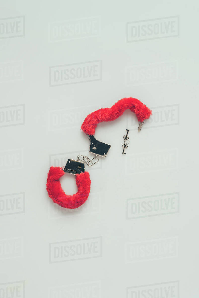 Top view of red fluffy handcuffs with keys isolated on white - Royalty ...