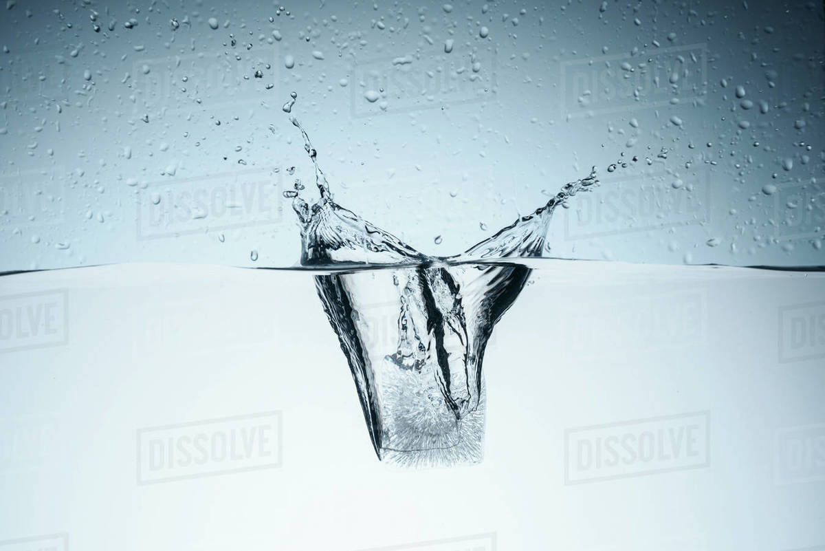 Ice cube in water with splash and drops, isolated on white - Royalty ...
