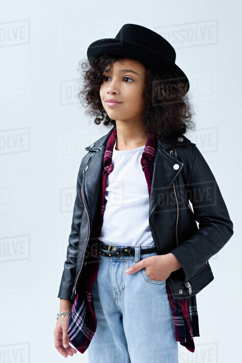 Stylish little child in leather jacket looking away isolated on grey ...