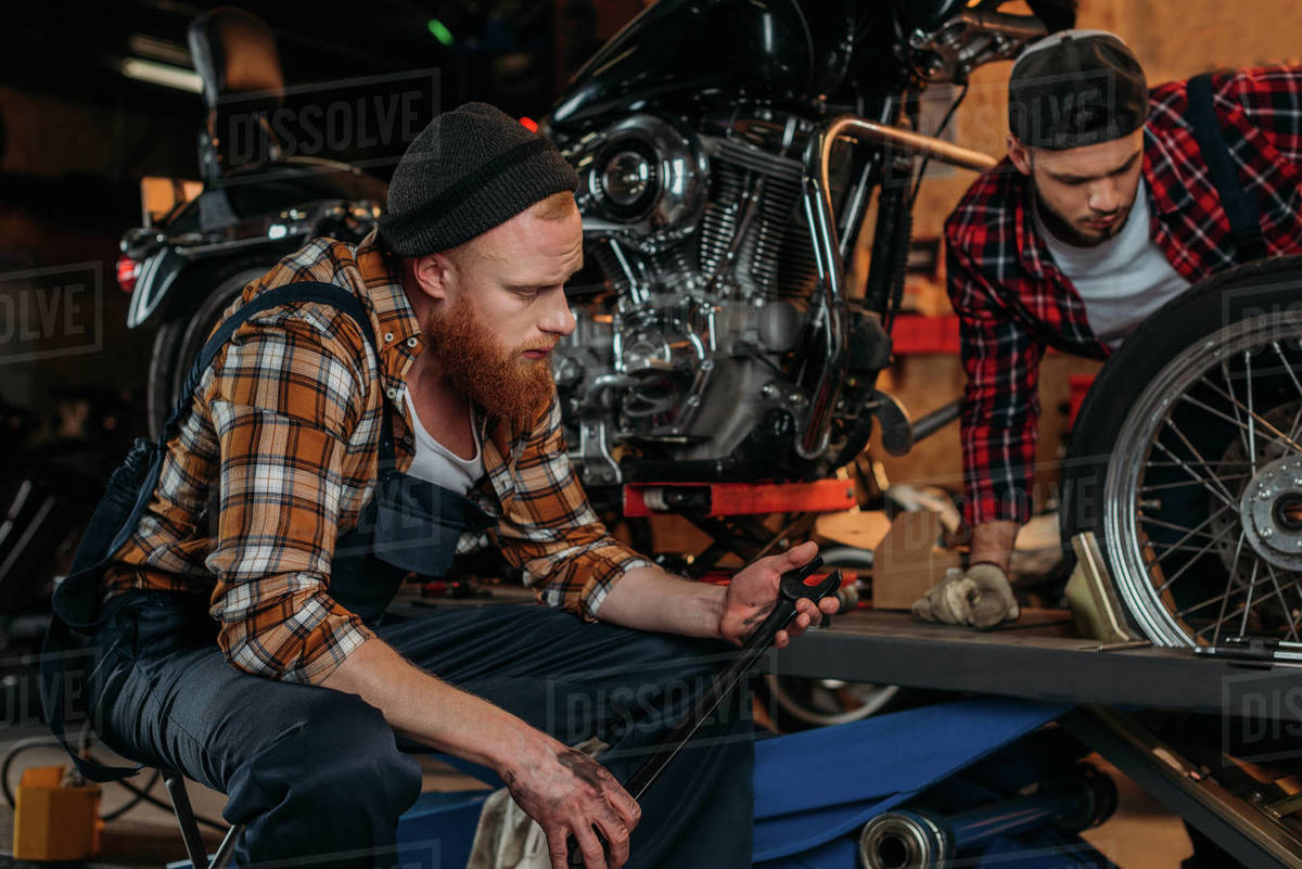 Handsome mechanics working together at custom garage - Royalty-free ...