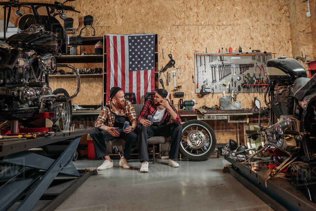 Happy mechanics having lunch together at garage - Stock Photo - Dissolve