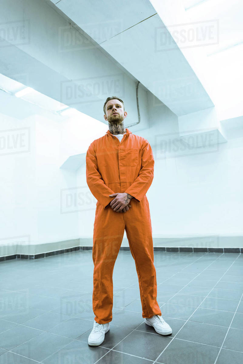 Bottom view of tattooed prisoner standing in prison cell - Royalty-free ...